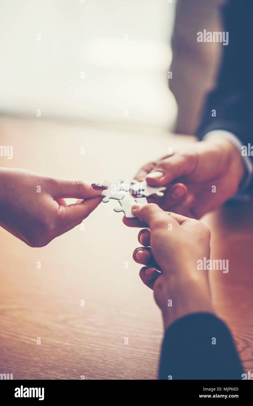 hands trying to connect couple puzzle piece with background, one part ...