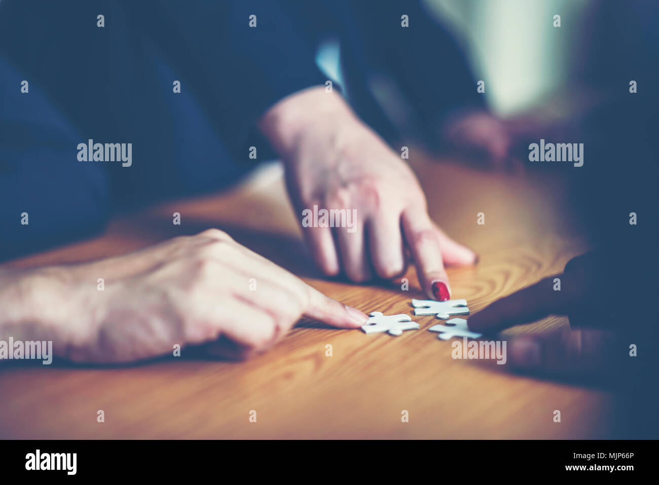 hands trying to connect couple puzzle piece with background, one part ...