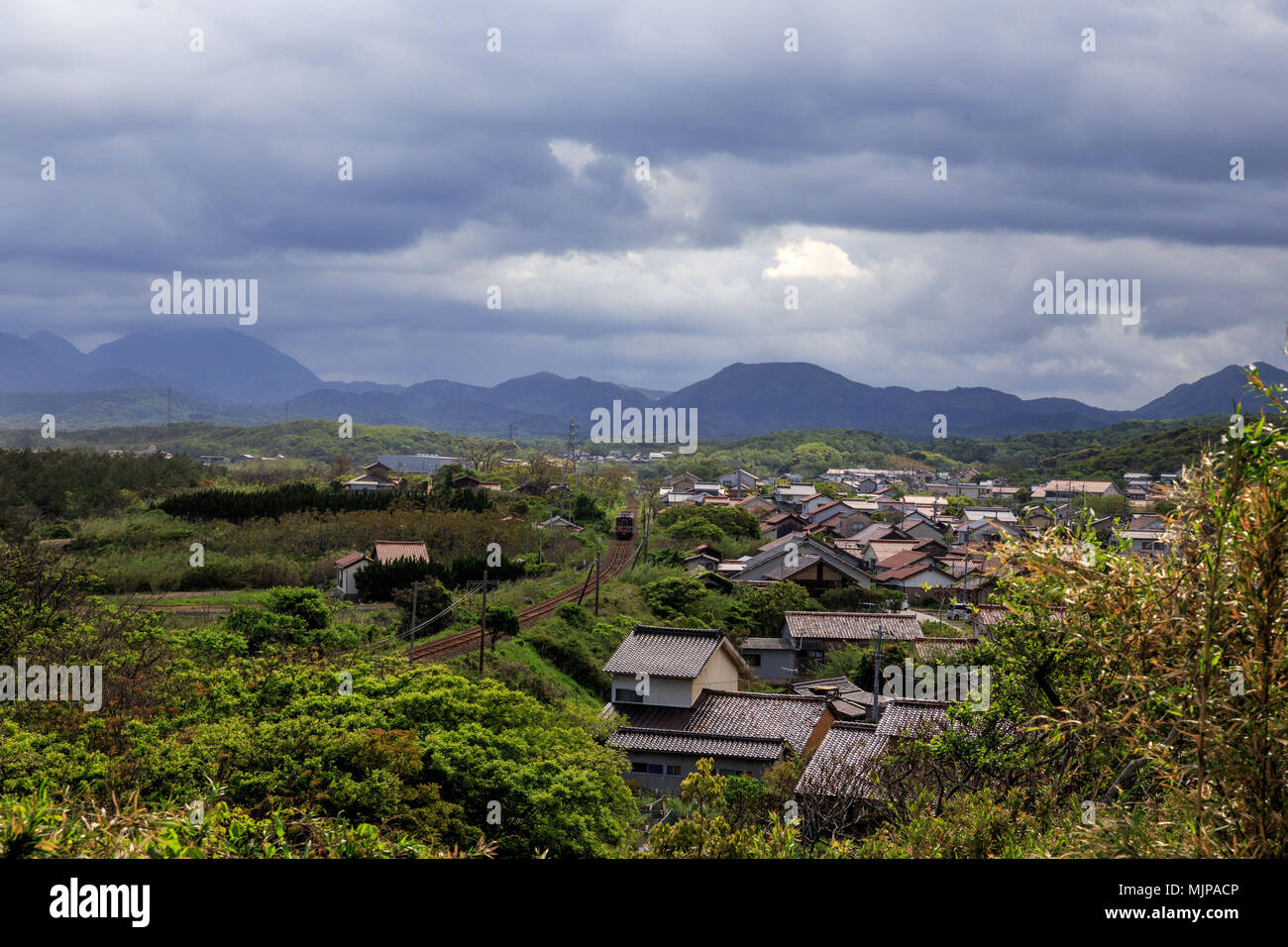 One car train on tracks running through small Japanese village Stock ...