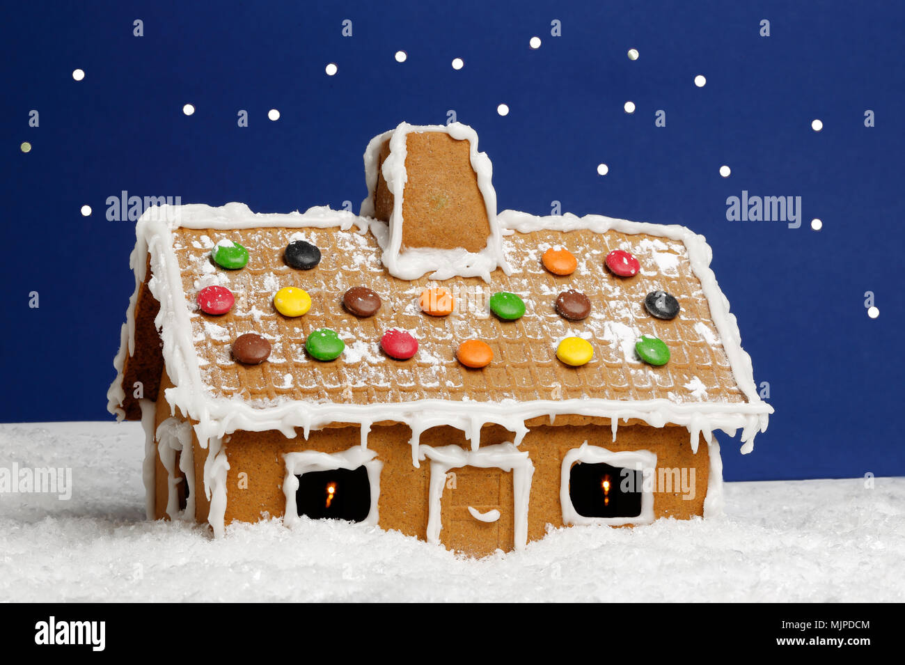 Gingerbread housesurronded by winter snow with a blue background with ...