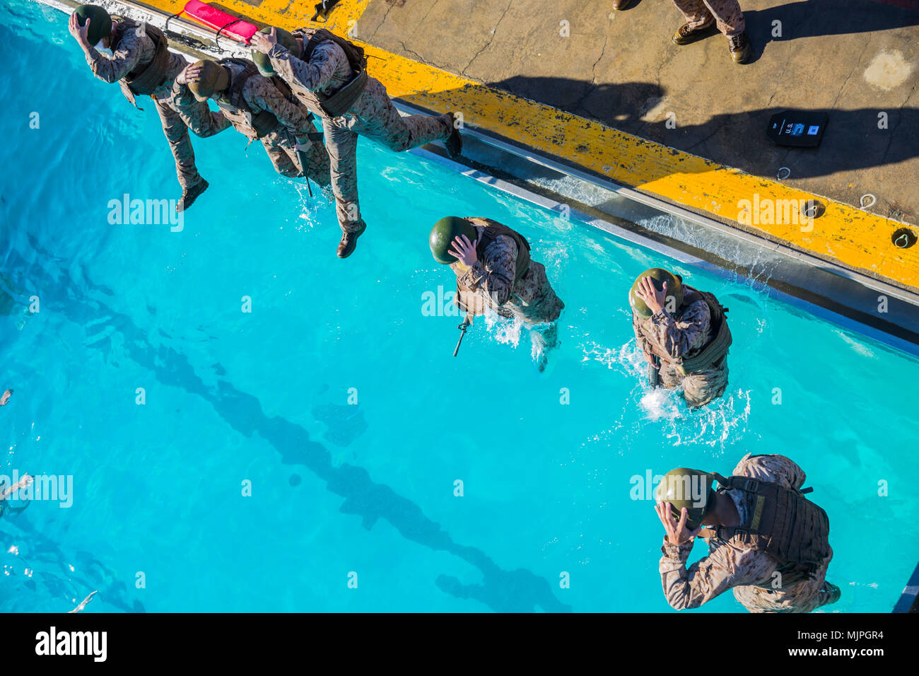 U.S. Marines with 7th Engineer Support Battalion jump into the water to ...