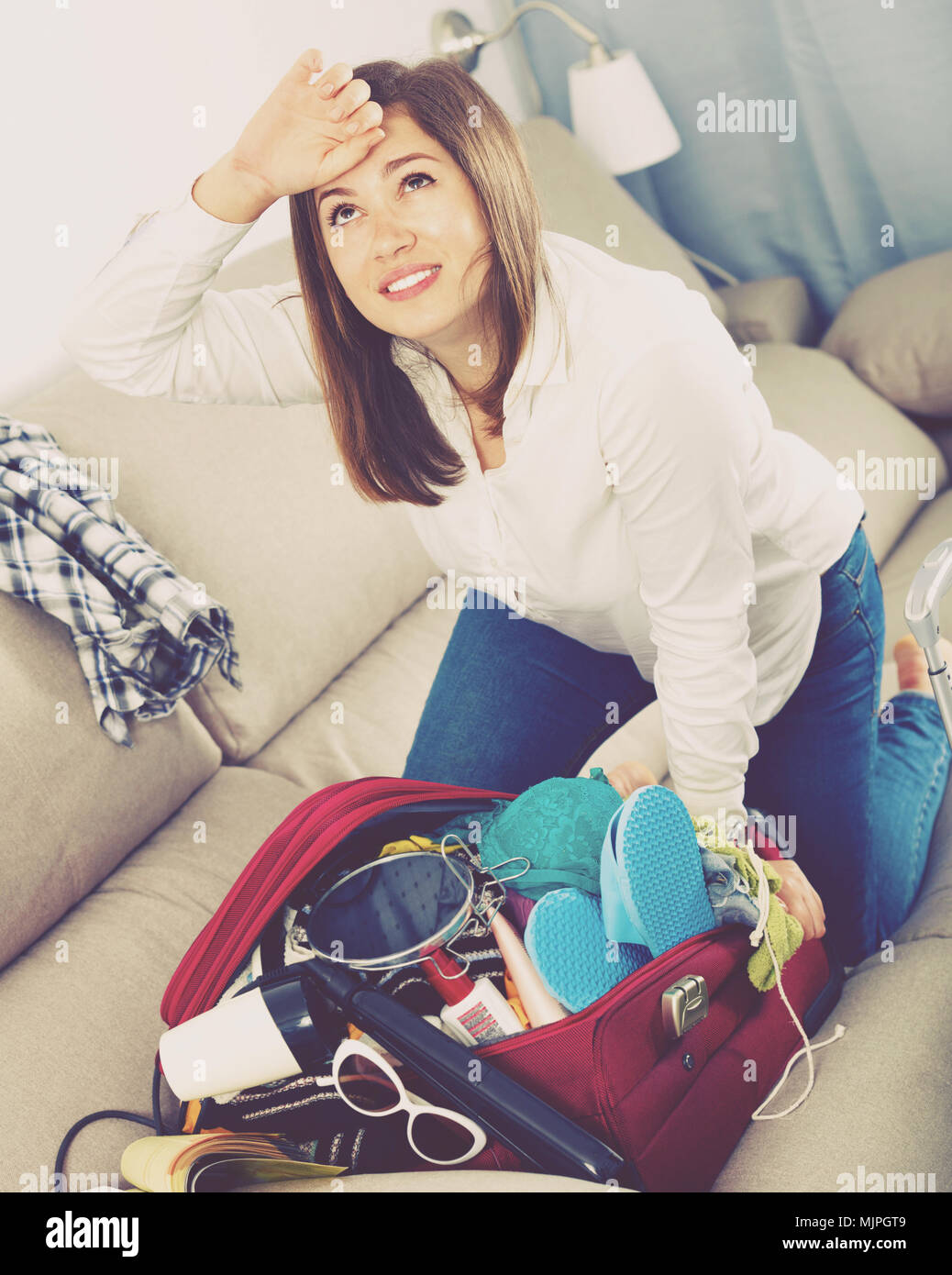 Happy positive girl starting packing luggage for journey at home Stock ...