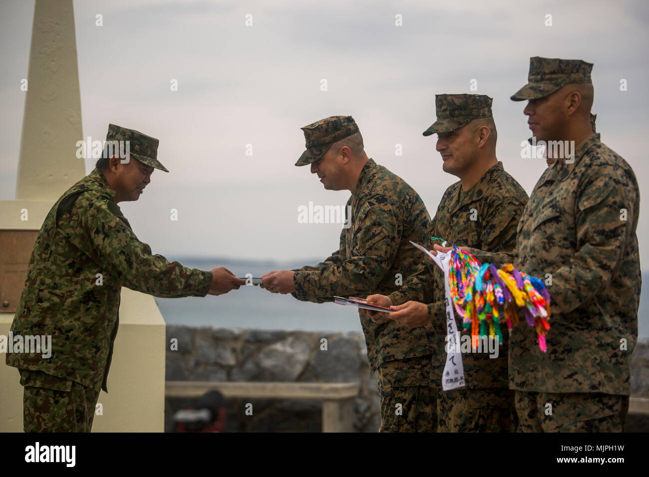 Japan Self-Defense Force Sgt. Maj. Mitsuru Yasura presents a token of ...