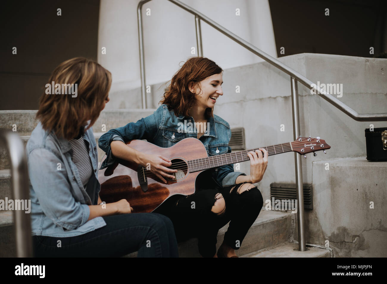 Cute Young Female Musicians Girl Friends Laughing and Singing on Urban ...