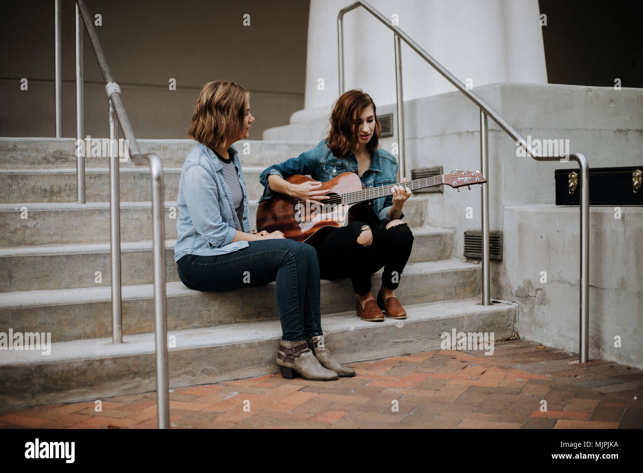 Cute Young Female Musicians Girl Friends Laughing and Singing on Urban ...