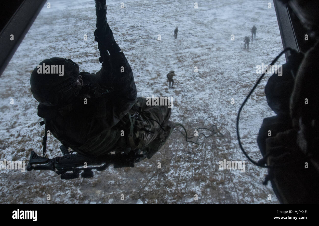 An Estonian Special Operations Forces operator fast ropes out the back ...
