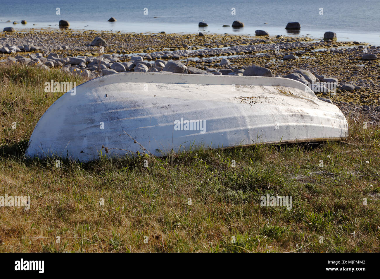 One small white boat up side down at the beach Stock Photo - Alamy