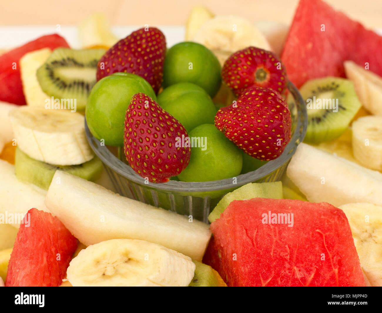 Fruits on the plate. Green plum, strawberry, banana, kiwi, watermelon ...