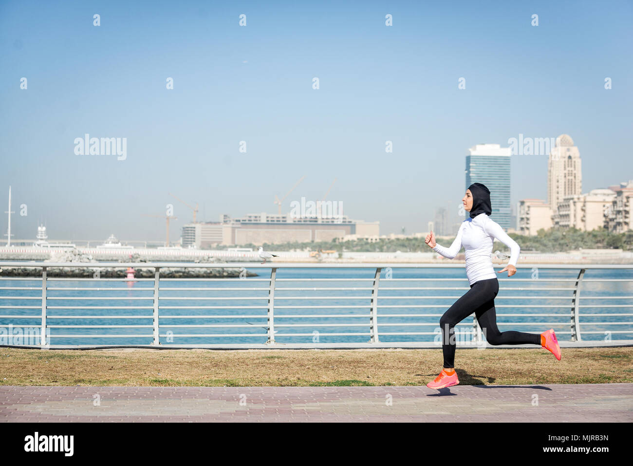 Arabic woman running outdoor and wearing hijab Stock Photo - Alamy