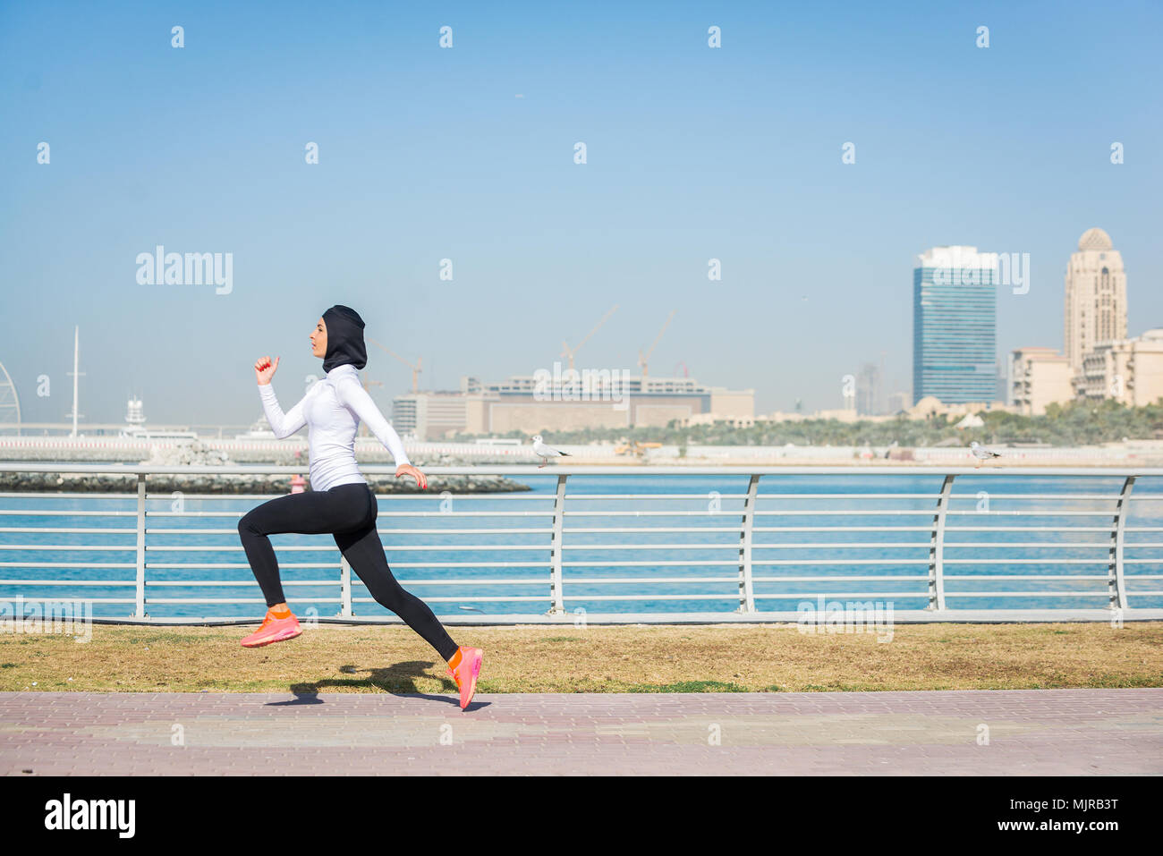 Arabic woman running outdoor and wearing hijab Stock Photo - Alamy