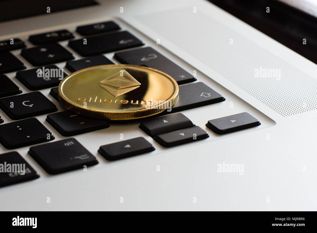 Ethereum cryptocurrency coin over a laptop's keyboard Stock Photo - Alamy