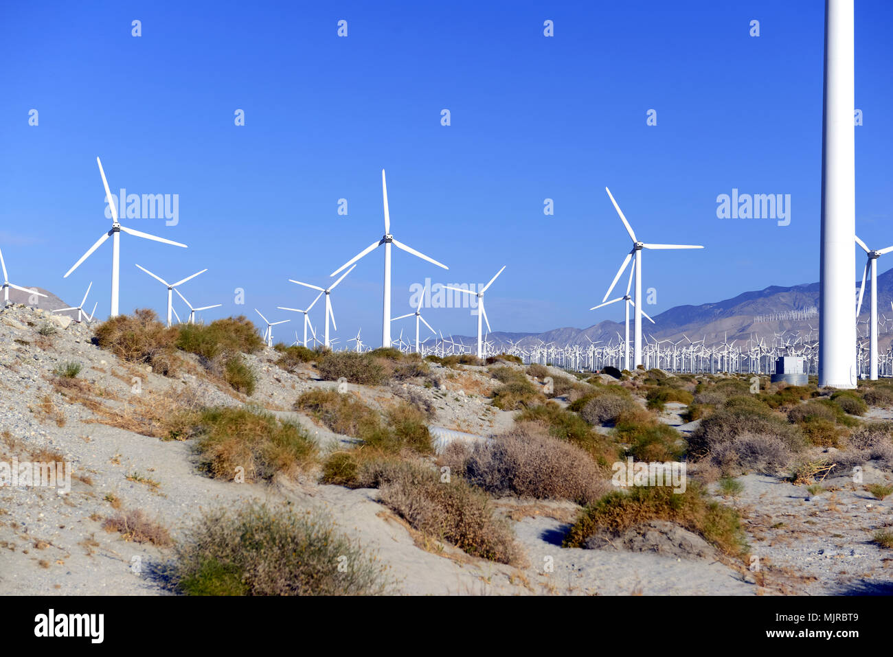 Wind turbines creating renewable energy on windfarm in desert with ...