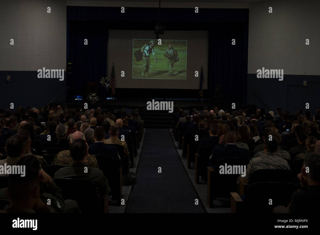 Guests watch a memorial service in honor of Capt. Mark Weber, March 21 ...