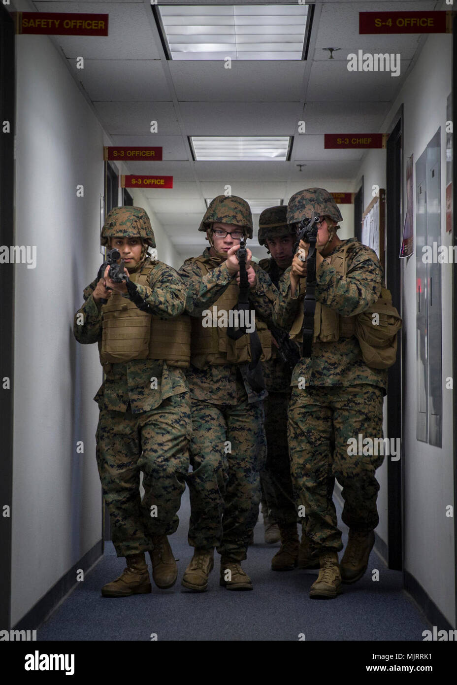 Marines attached to the 11-18 Area Guard maneuver through a hallway ...