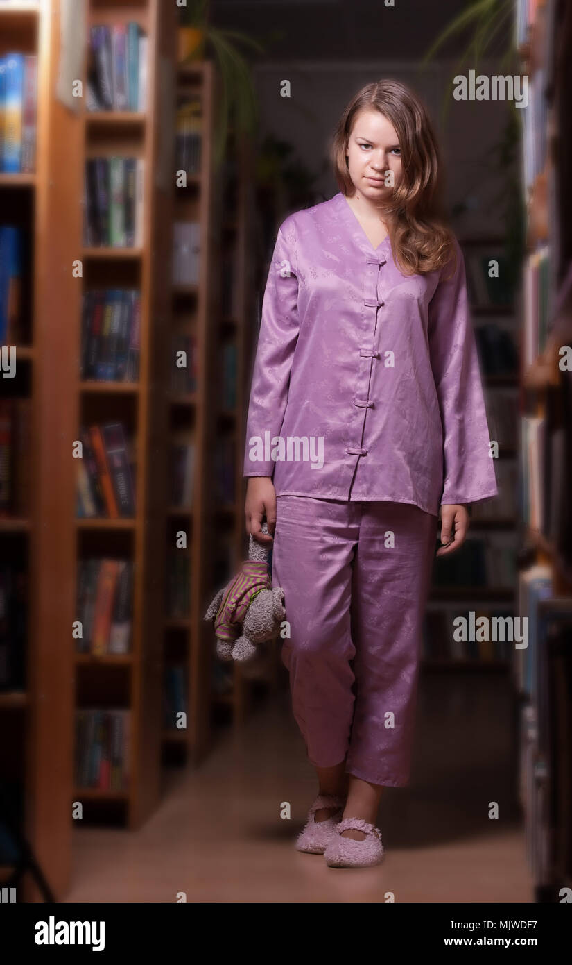 Girl in pajamas and slippers at night in the library survey in the ...