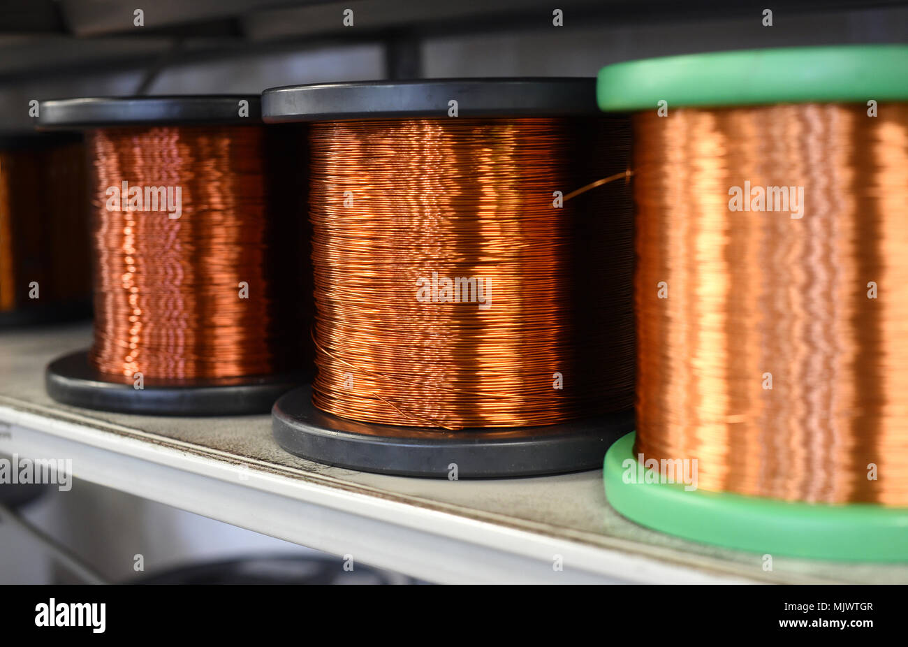 Row of copper wire coils standing on shelf in close up view Stock Photo ...