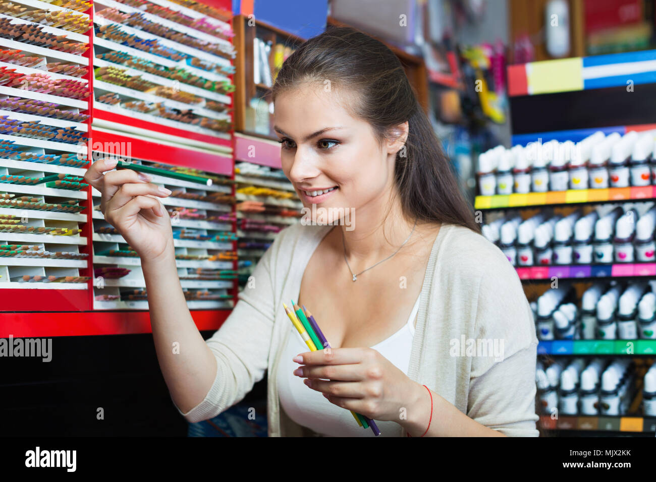 Portrait of pleasant glad cheerful woman choosing pencils for drawing ...