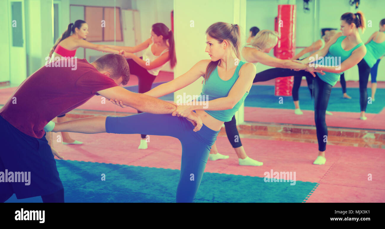 Sporty cheerful girl with her instructor are training self-defence ...