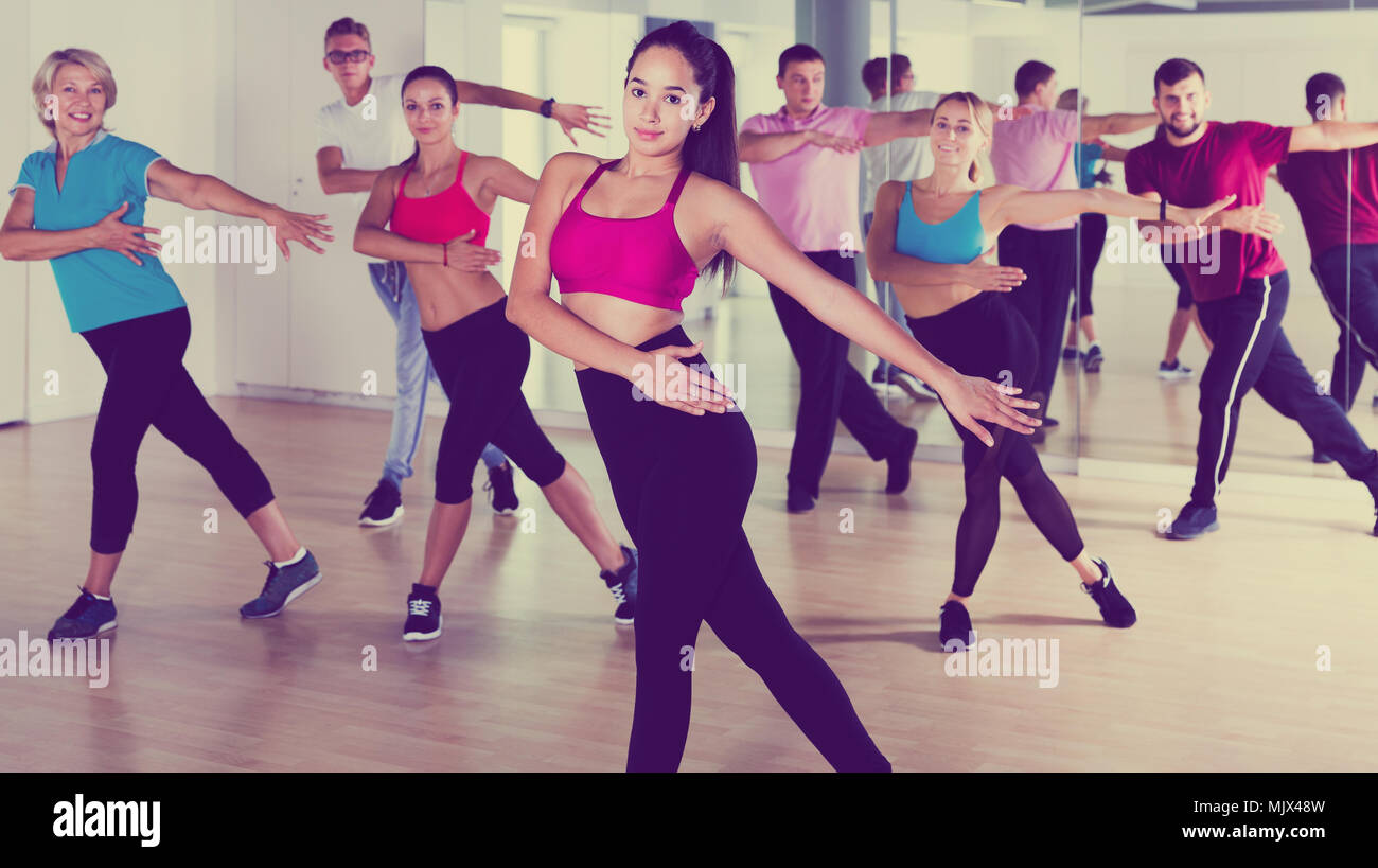 Cheerful different ages people learning swing steps at dance class ...