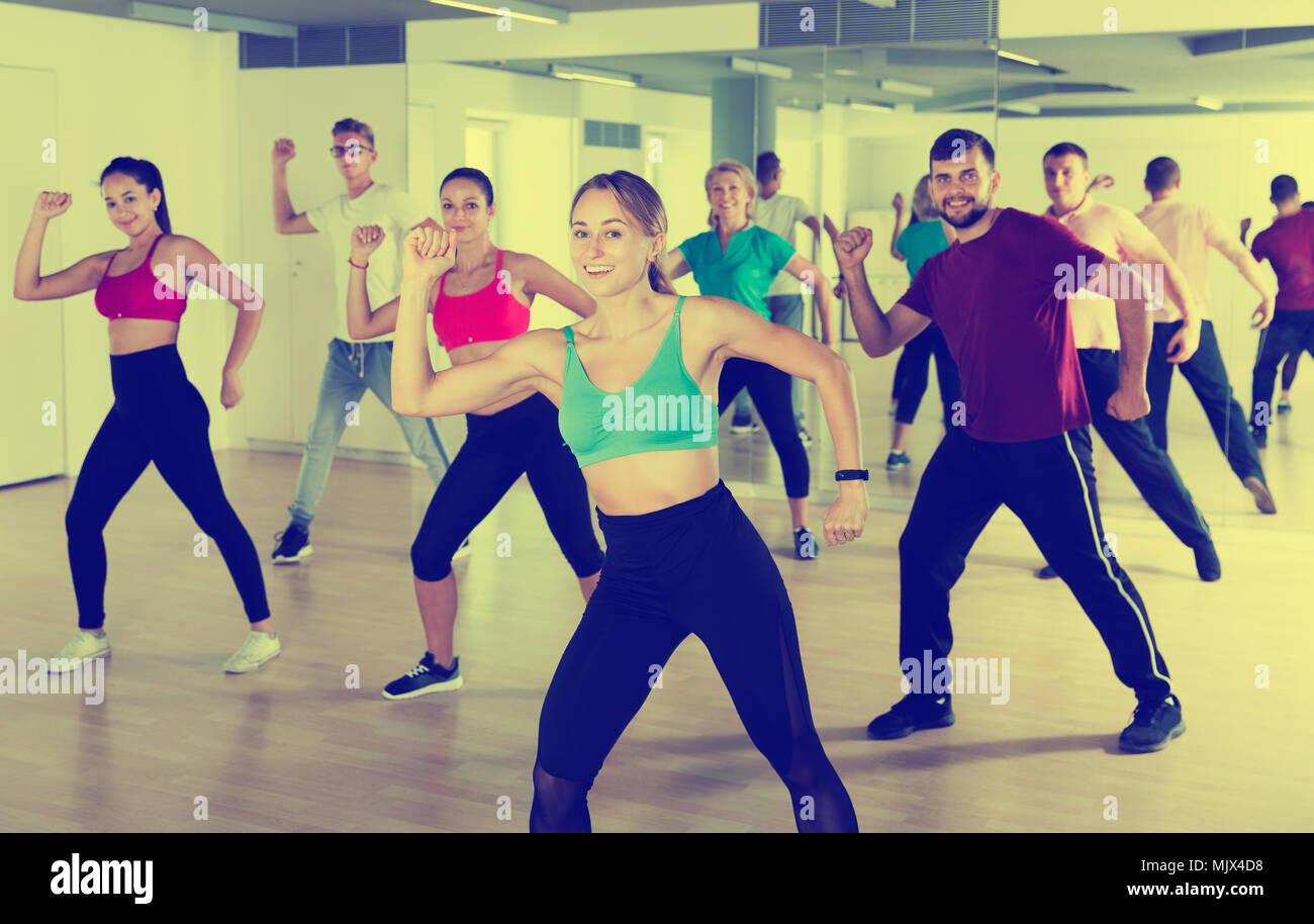 glad active sporty adults of different ages dancing at dance class ...