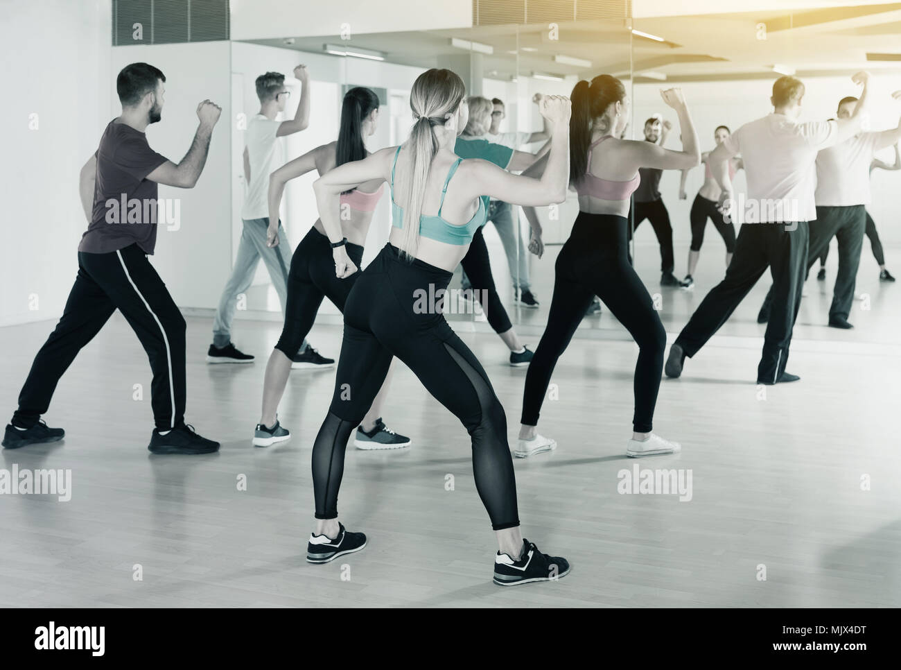 positive men and ladies dancing aerobics at lesson in the dance class ...