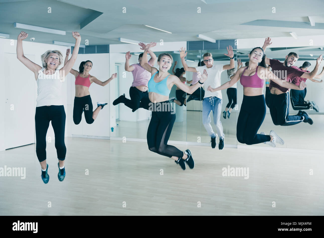 Happy sporty different ages adults jumping at dance class Stock Photo ...