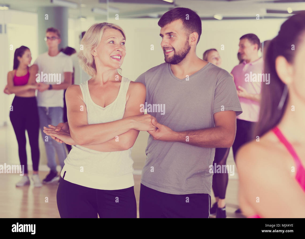 Group of positive smiling young adults dancing salsa in club Stock ...