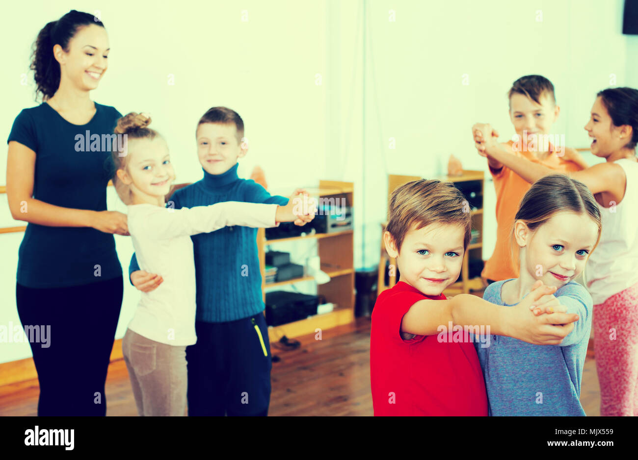Group of children with teacher dancing pair dance in dance hall Stock ...