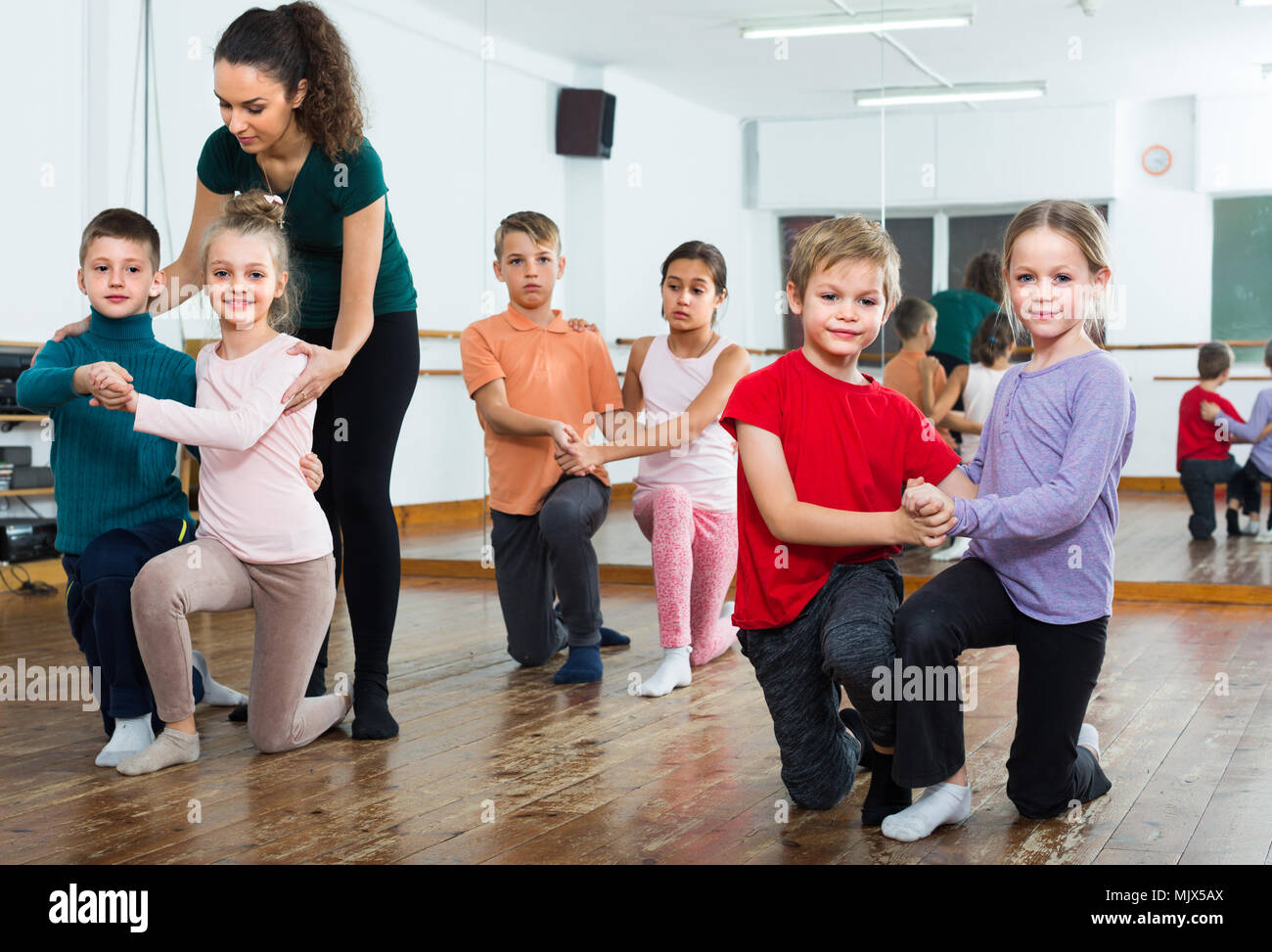 Group of positive children dancing tango and salsa in dance studio ...