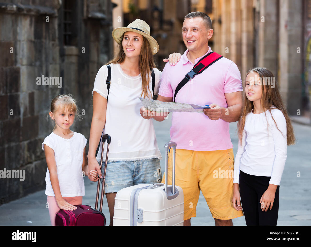 Glad family of tourists with two children looking for destination with ...