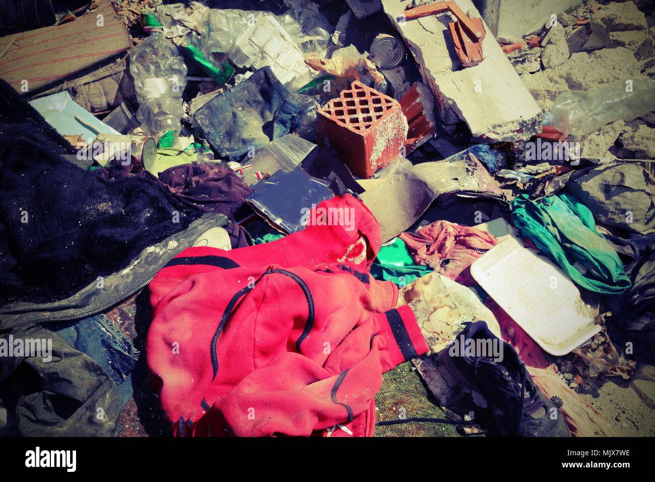 red sweatshirt in the middle of rubbish heaps and many rags in a ...