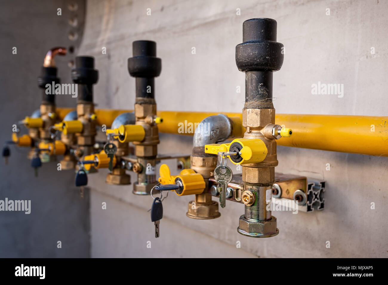 Gas pipe and valve with lock on the wall Stock Photo - Alamy