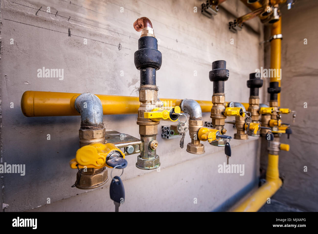 Gas pipe and valve with lock on the wall Stock Photo - Alamy