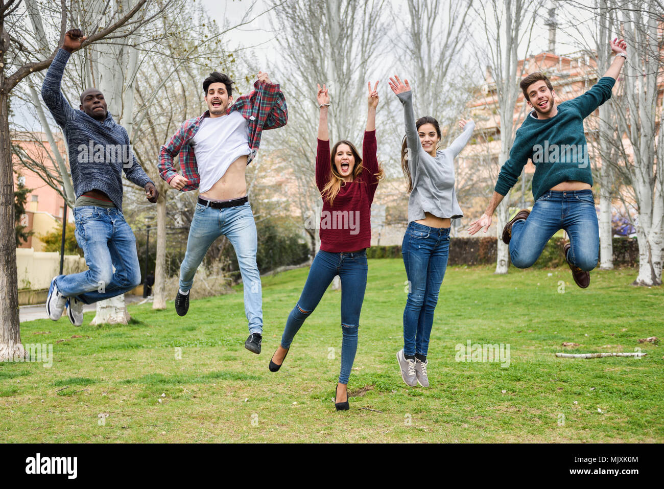 Group of multi-ethnic young people jumping together outdoors Stock ...