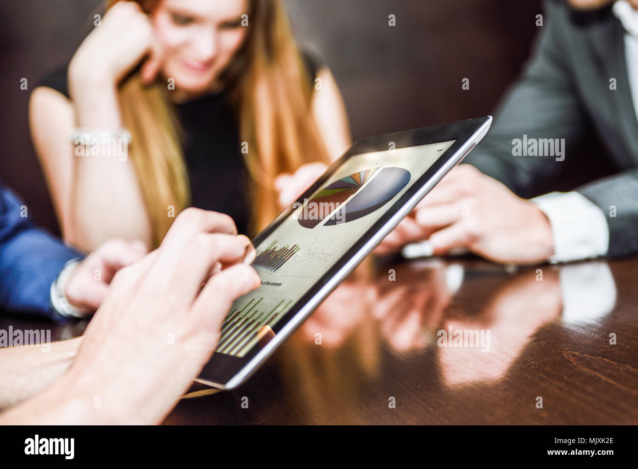 Close-up of a modern business team using tablet computer to work with ...