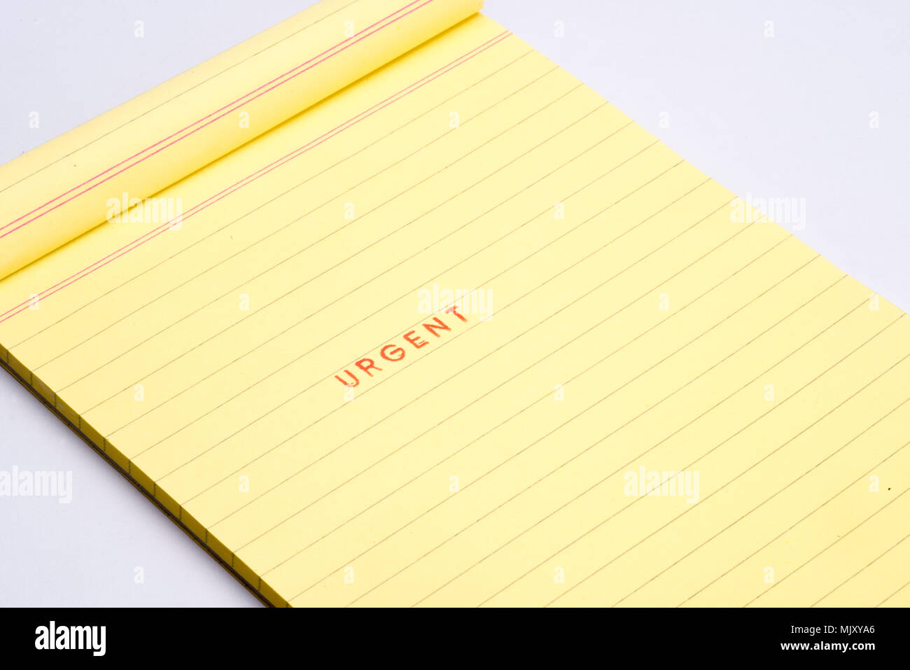 "URGENT" rubber stamp on yellow note pad Stock Photo - Alamy