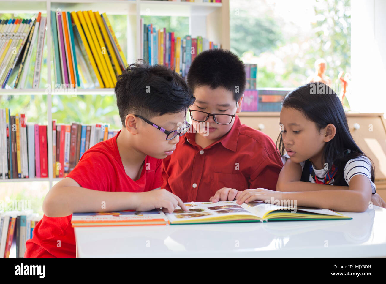 Asian boy and asian girl are reading together with happiness in their ...