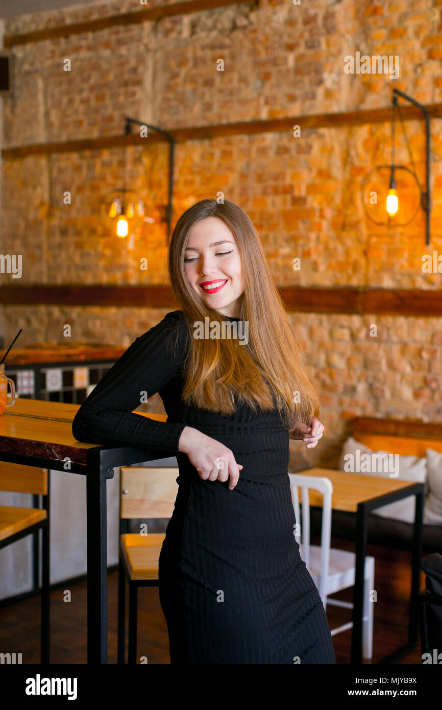 Girl sitting near table in cafe Stock Photo - Alamy