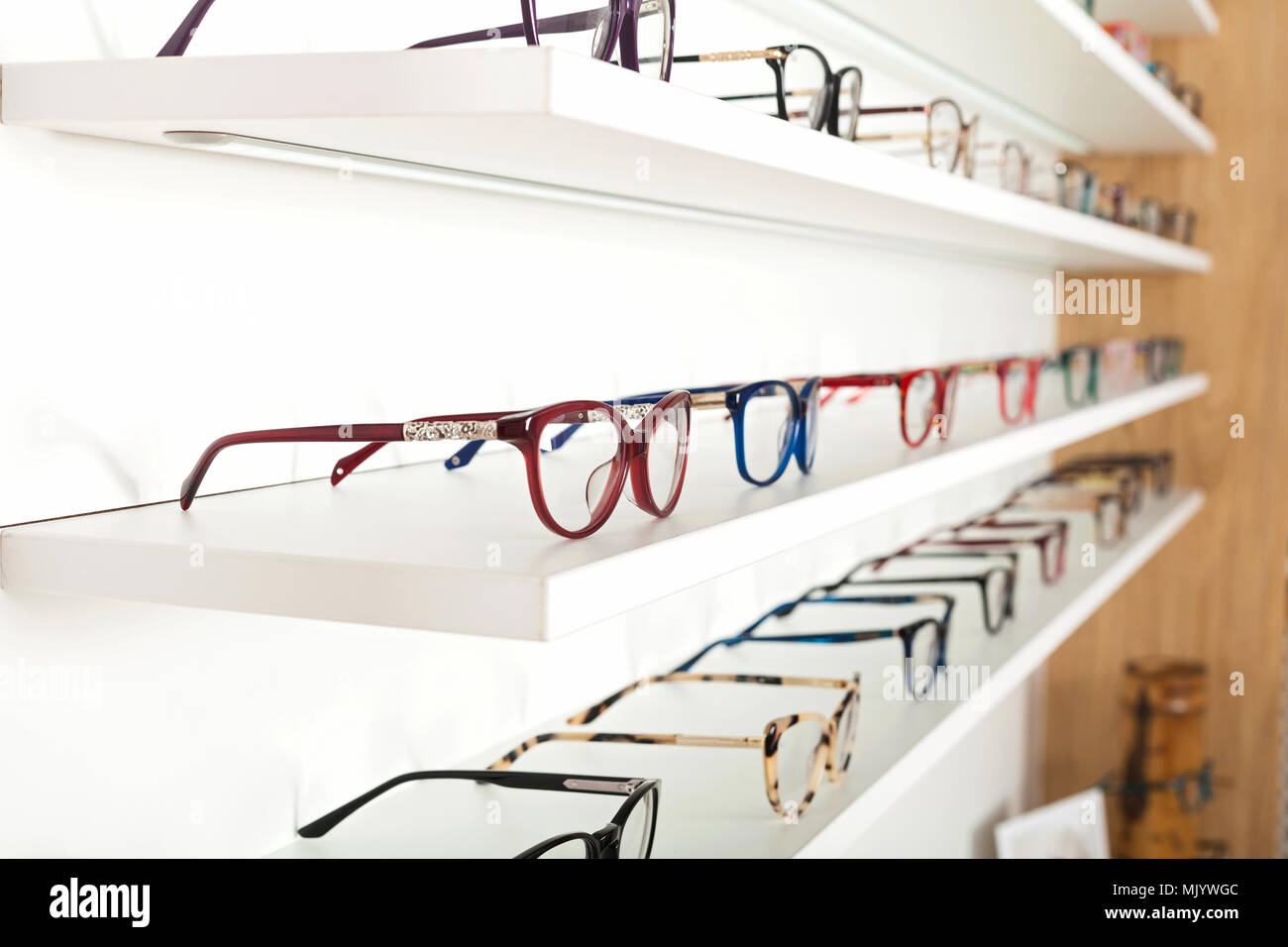 Fashionable corrective eye glasses on a shelf in optical store Stock ...