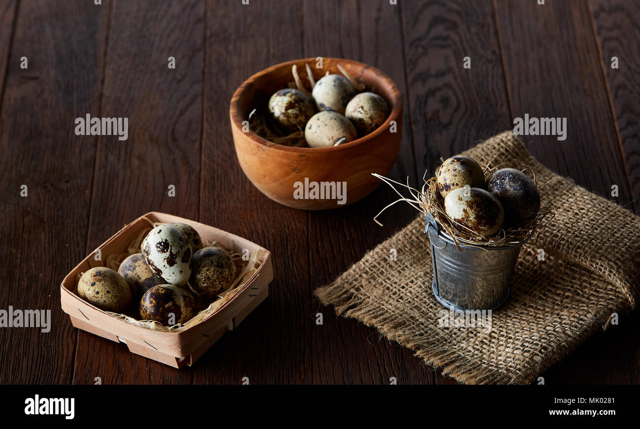Rustic still life with fresh quail eggs in decorative metal bucket with ...