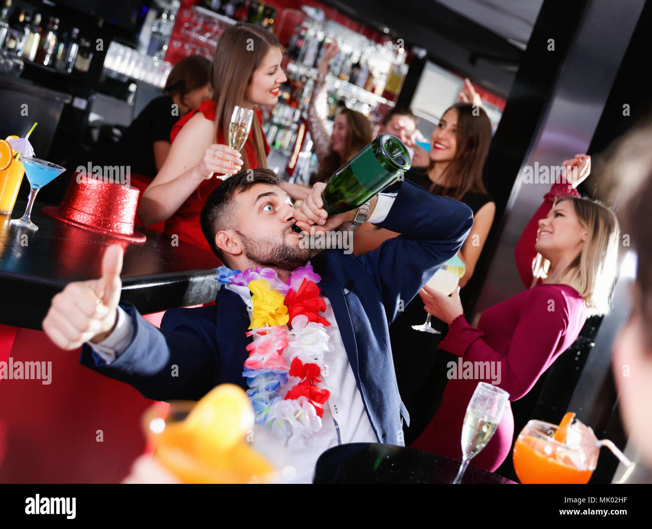 Happy cheerful positive guy drinking alcohol from bottle and dancing on ...
