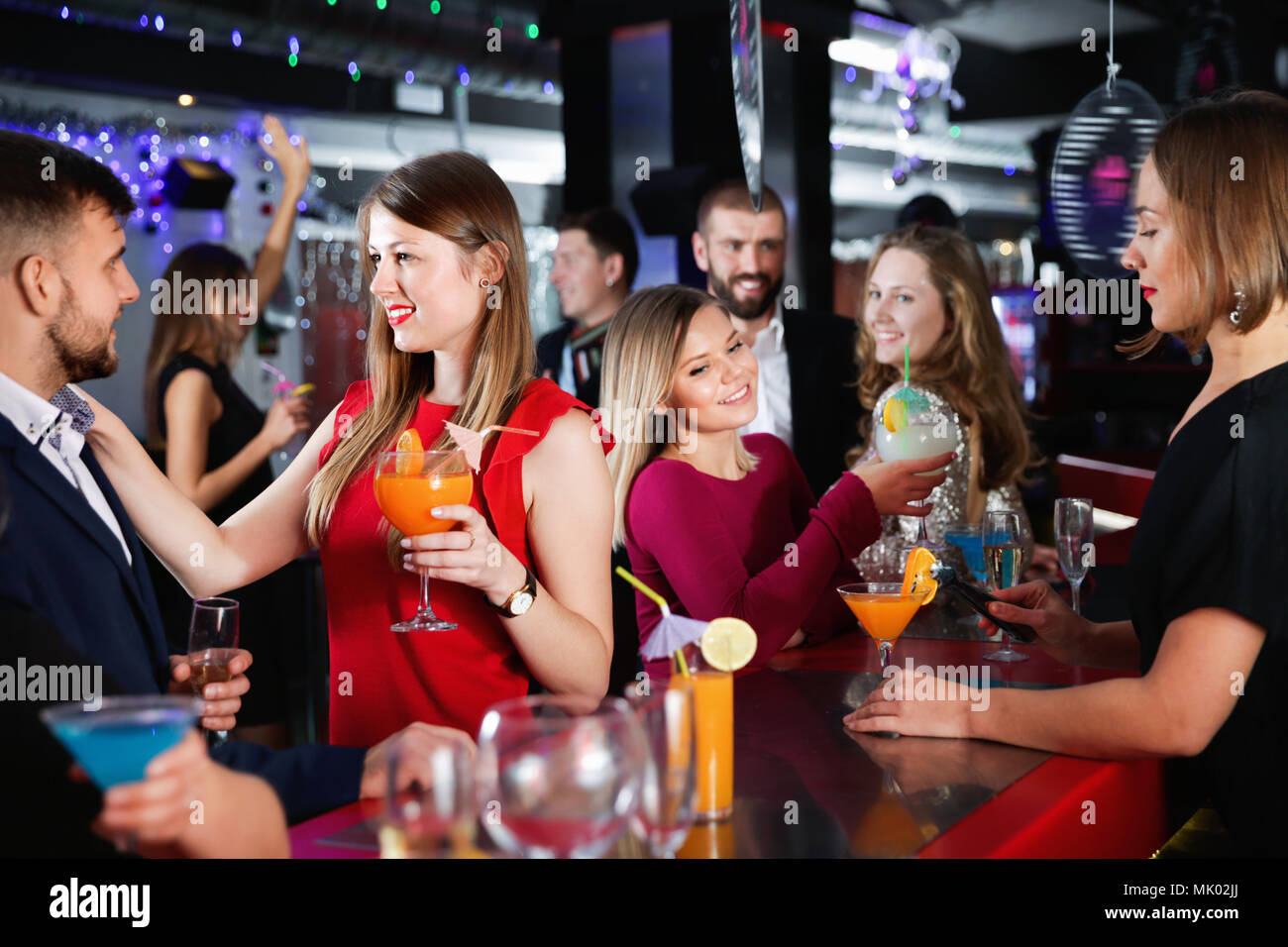 Young cheerful woman and her boyfriend with cocktails having fun at ...