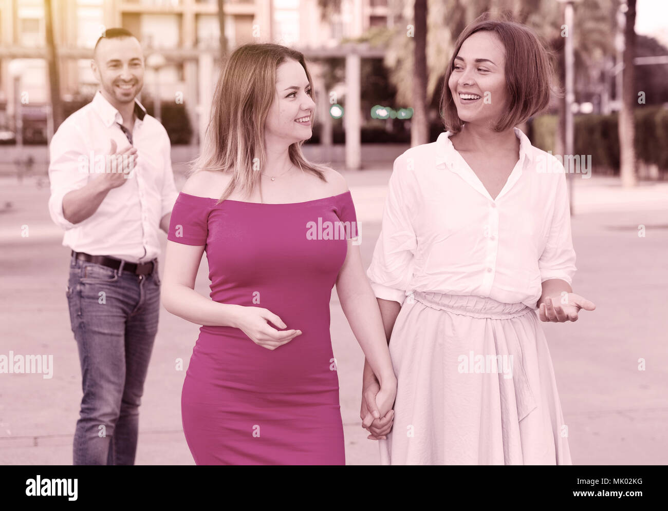 Young women are walking and stranger man is want acquaintance with them ...