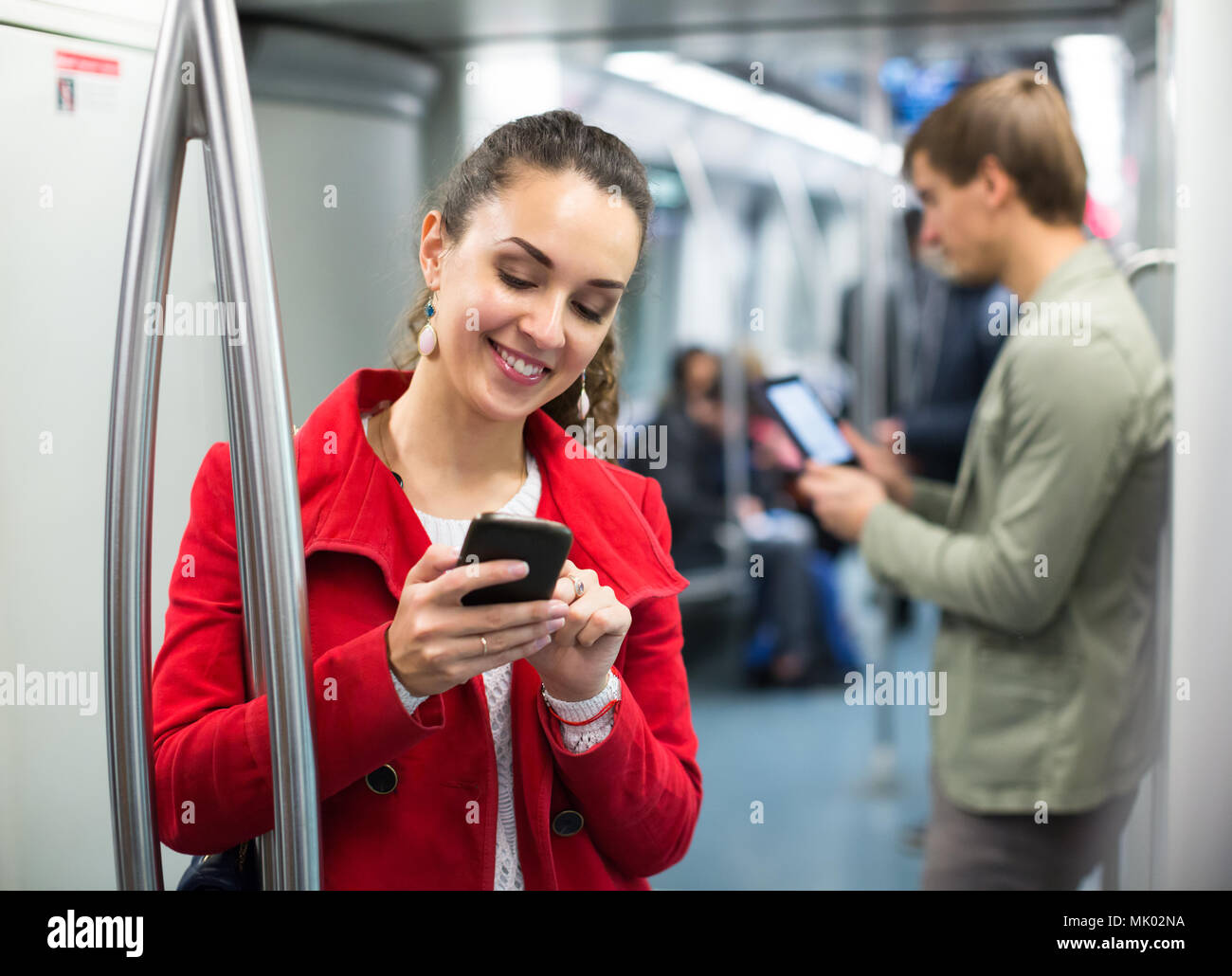 Young subway passengers busy with phones and tablet Stock Photo - Alamy