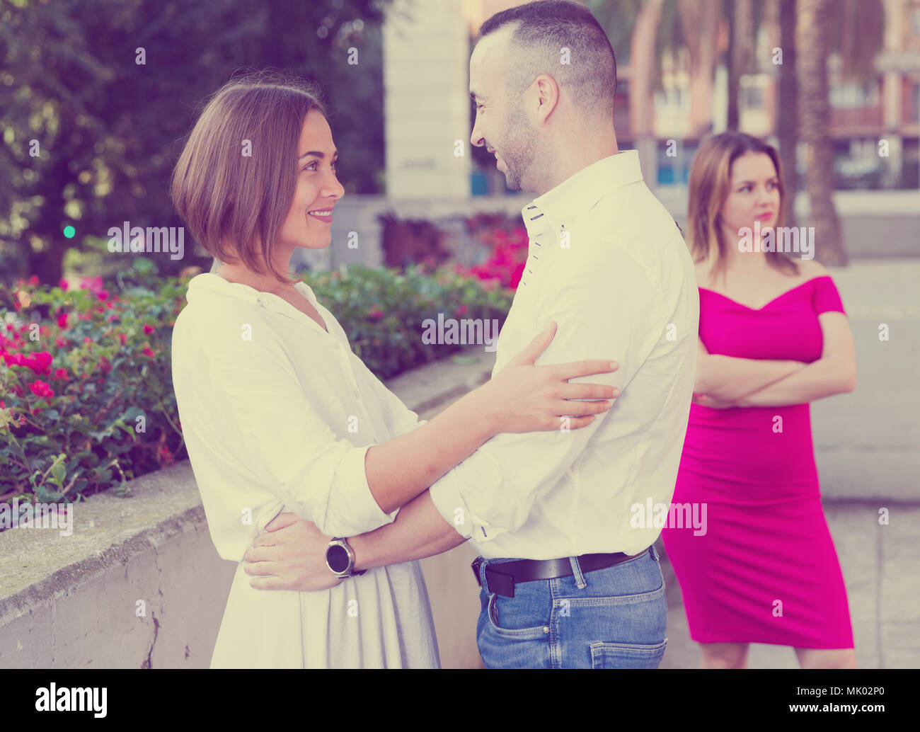 Young woman is flirting with boyfriend when her girlfriend is envying ...