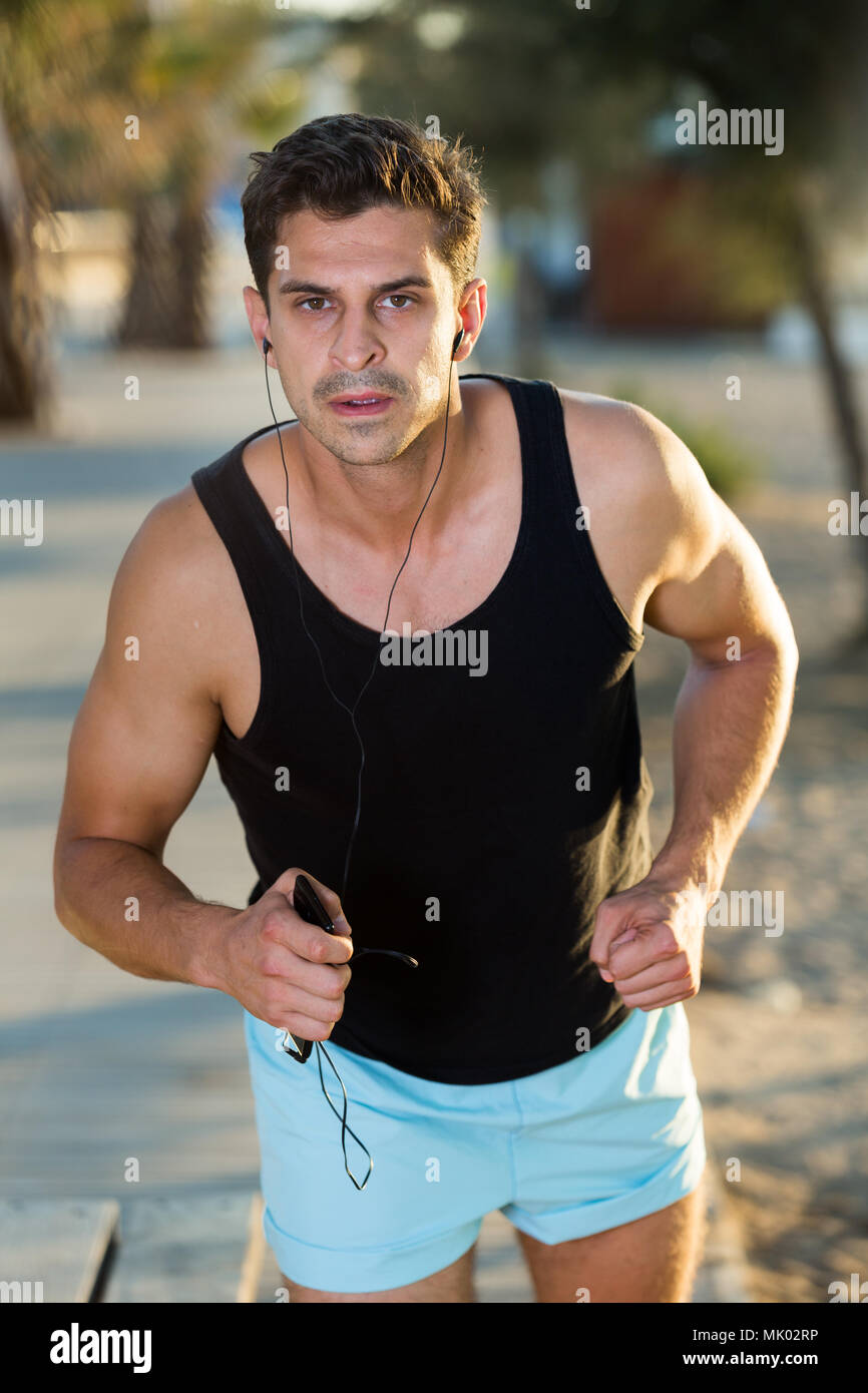 Man leading healthy lifestyle, jogging during outdoor workout on city ...