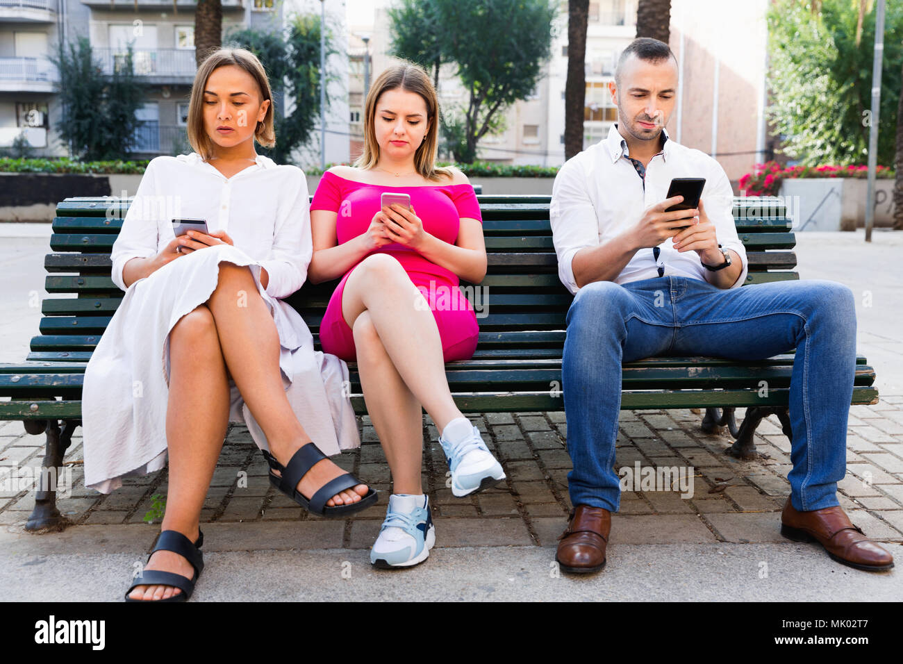 Young smiling cheerful positive people are focusing on smartphones ...