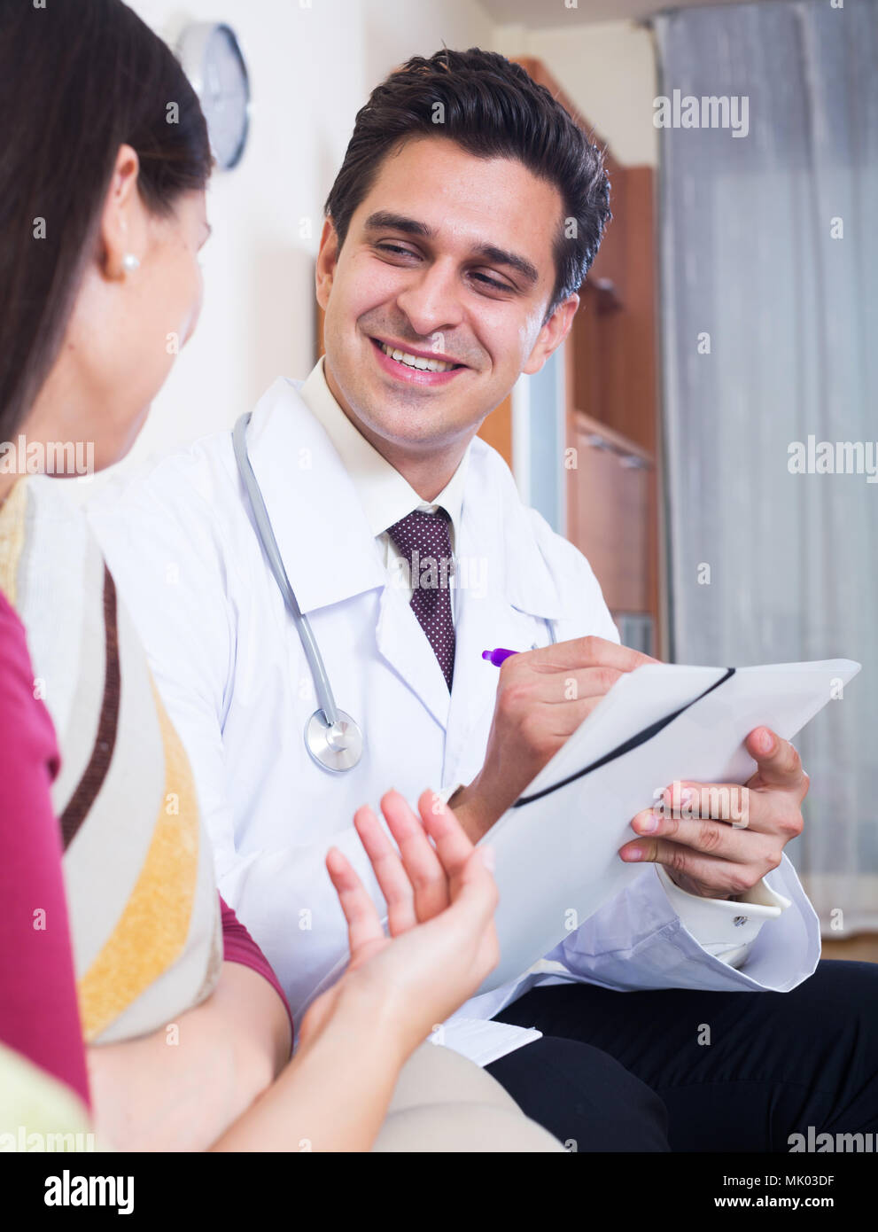 Professional doctor paying female patient a visit for checkup Stock ...