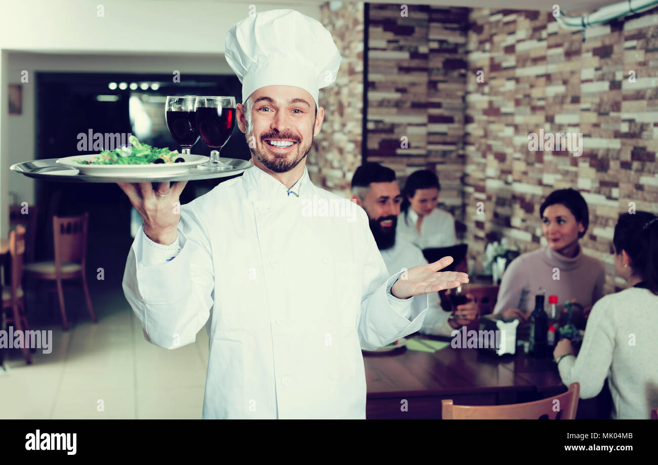 Happy male chef demonstrating country restaurant to visitors Stock ...