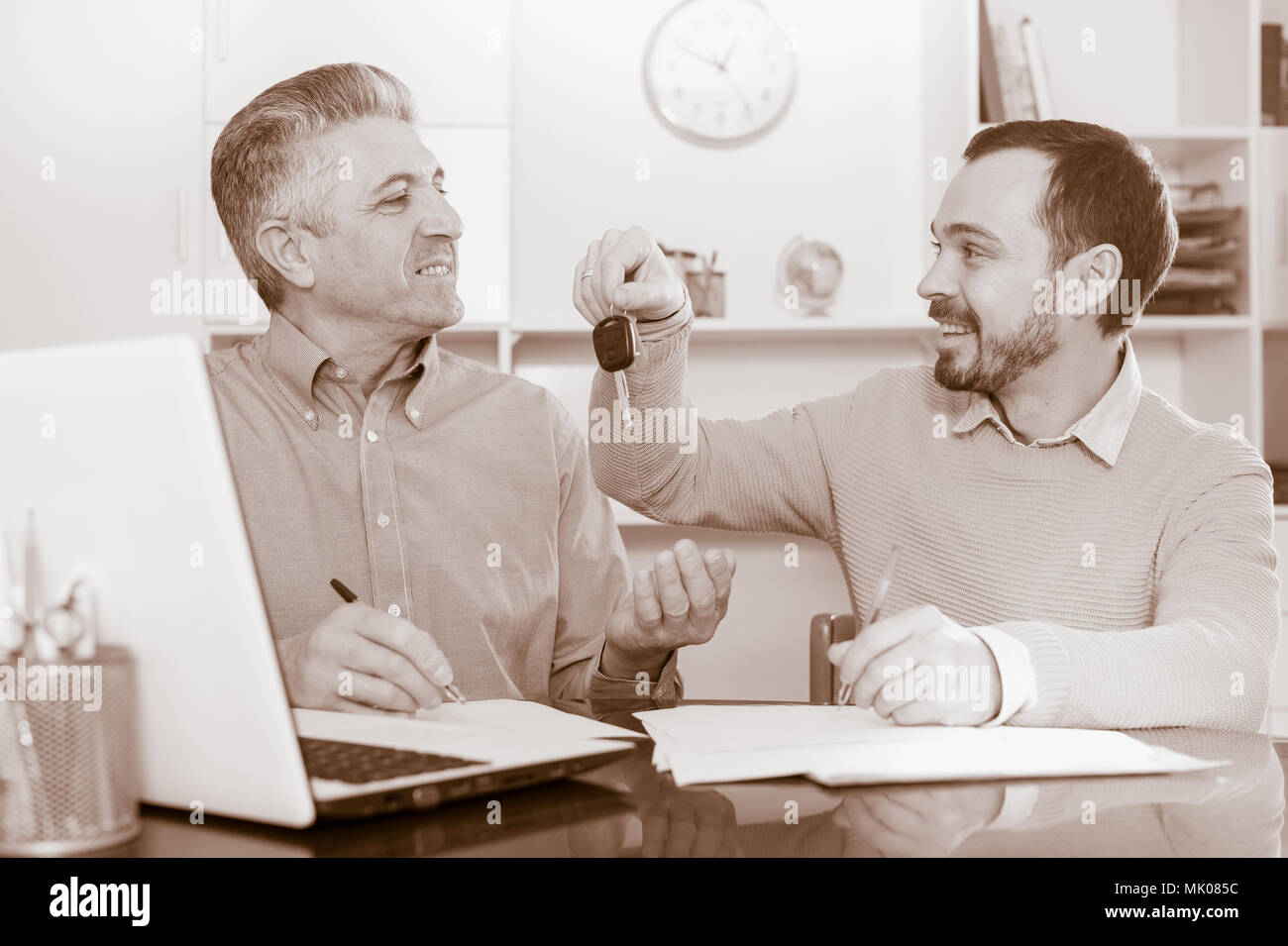 Middle man and manager sign car purchase contract and hand over keys ...